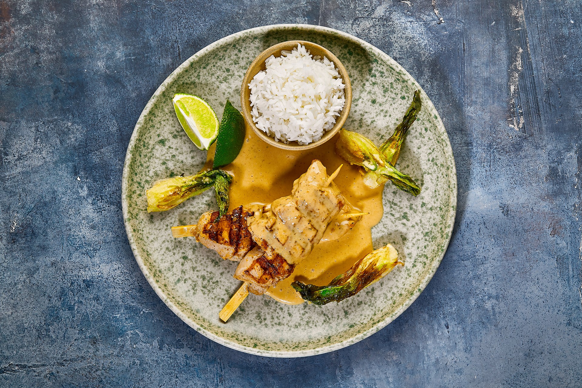 Satay af langefilet serveret med sataysauce og stegt pak choy ...