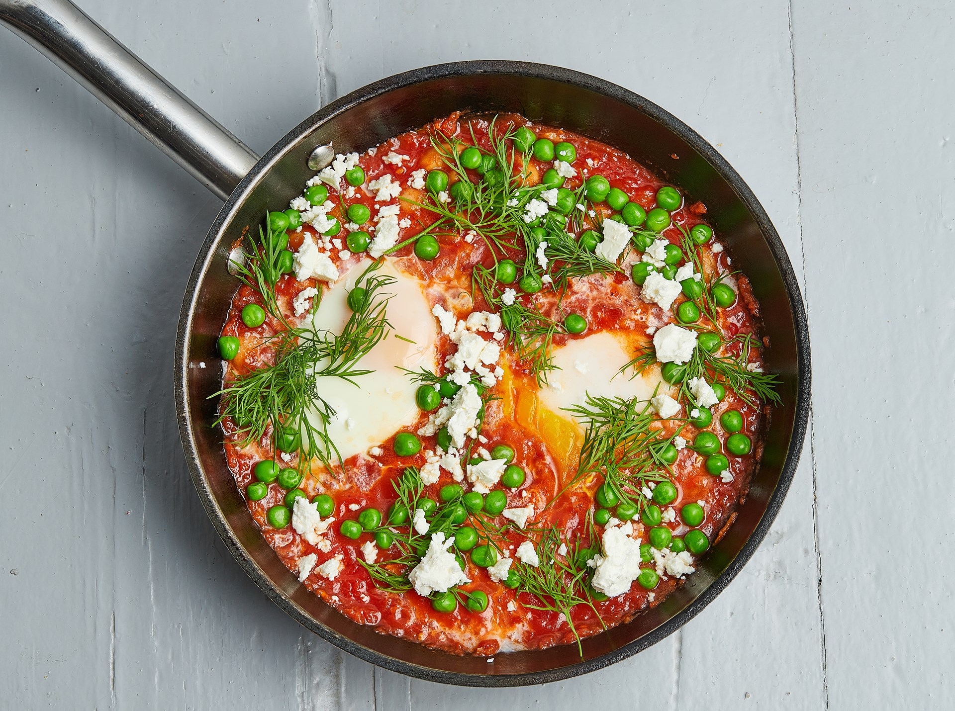 Shakshuka med ærter, cremet friskost og hvide bønner - Opskrift fra ...