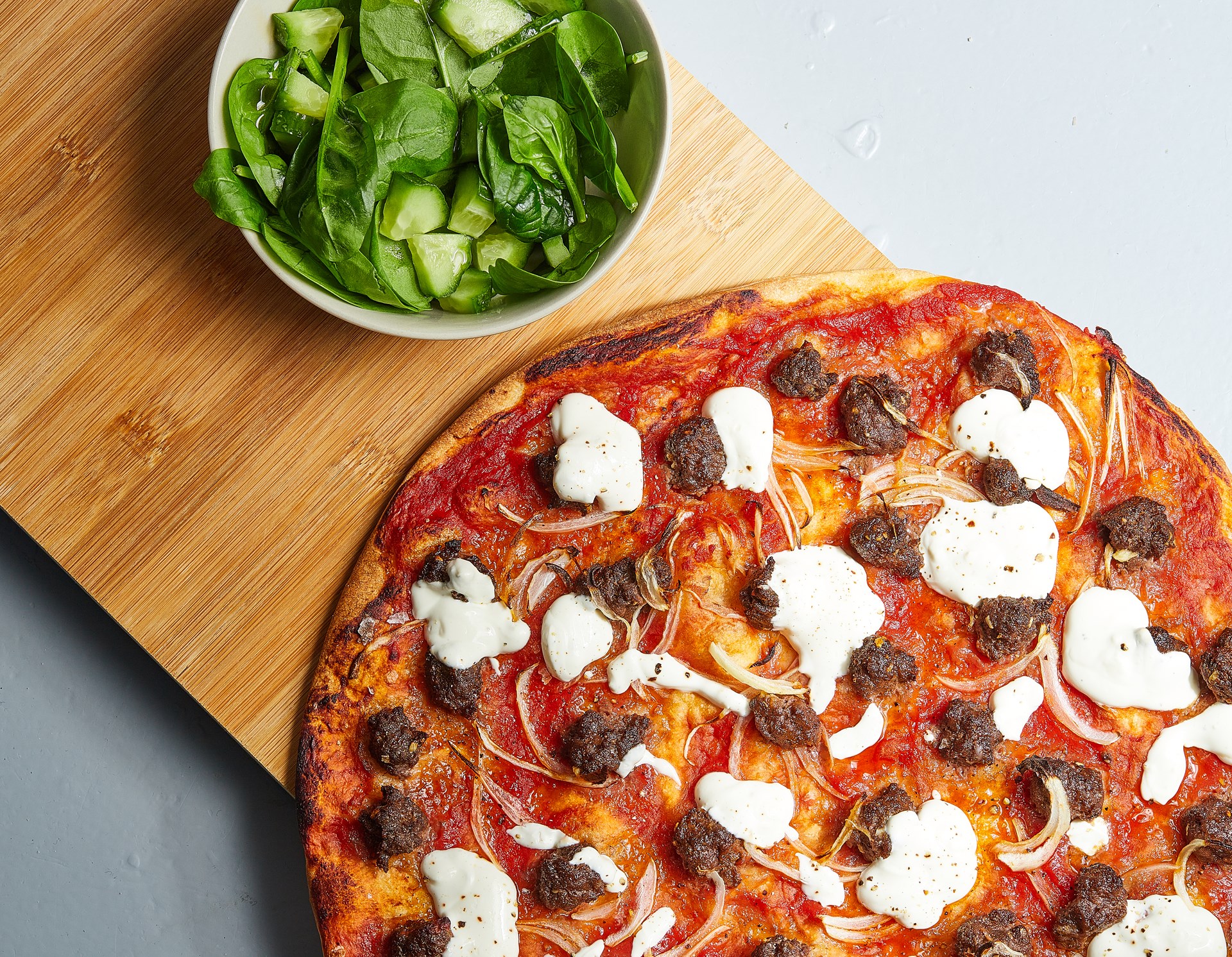 Pizza med minikødboller, creme fraiche dressing og spinatsalat ...
